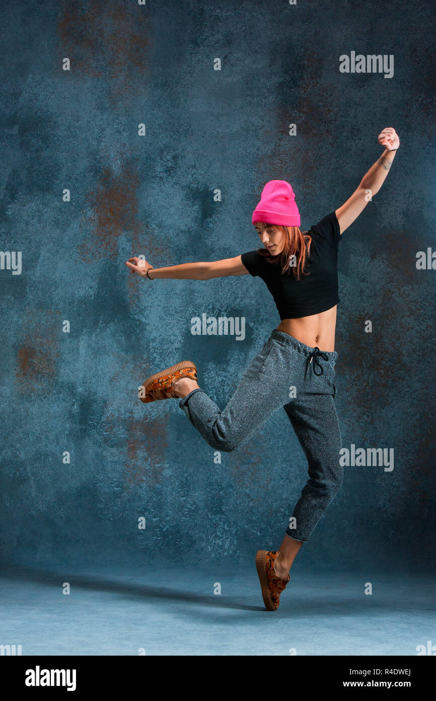 Young girl break dancing on blue studio background Stock Photo - Alamy