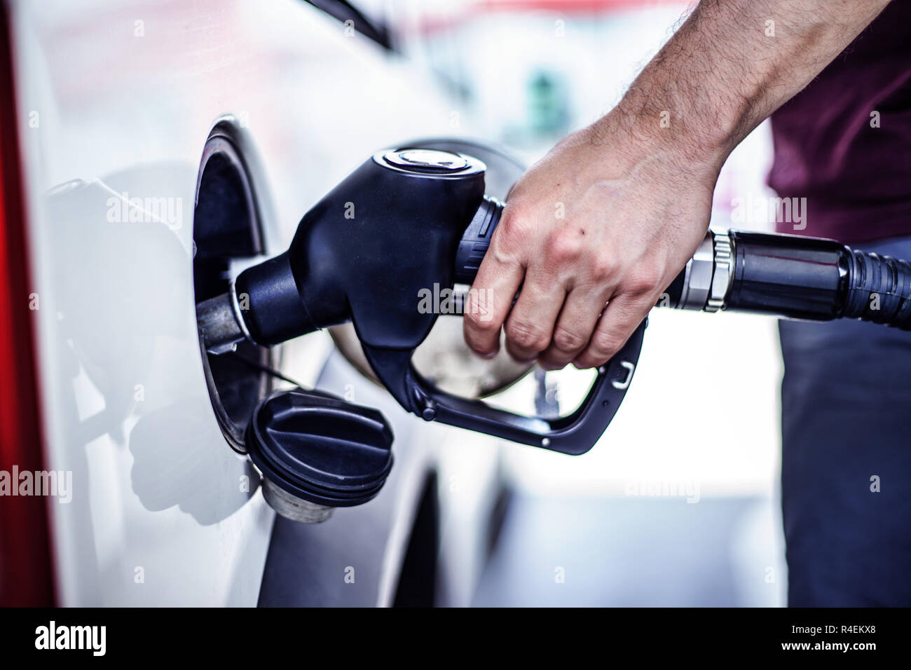 Man fulling tank with fuel at bokeh background Stock Photo - Alamy