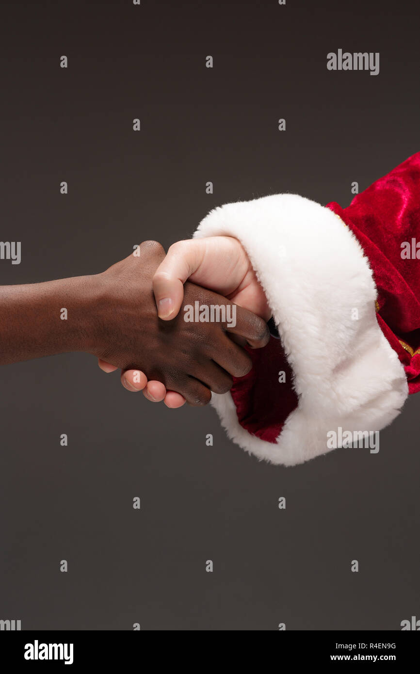 The handshake of Santa Claus hand and hand of african man Stock Photo ...