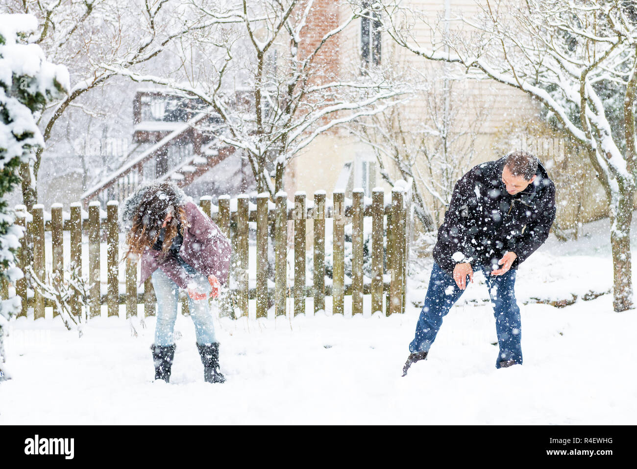 Young woman, man playing, throwing flying snowballs mid-air, air in ...