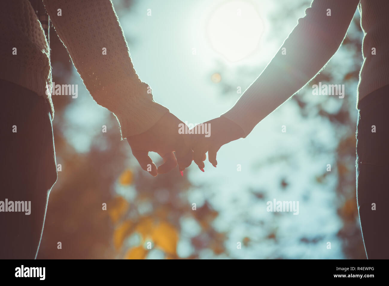 Attractive, beautiful couple is holding hands outdoors on a sunny day ...