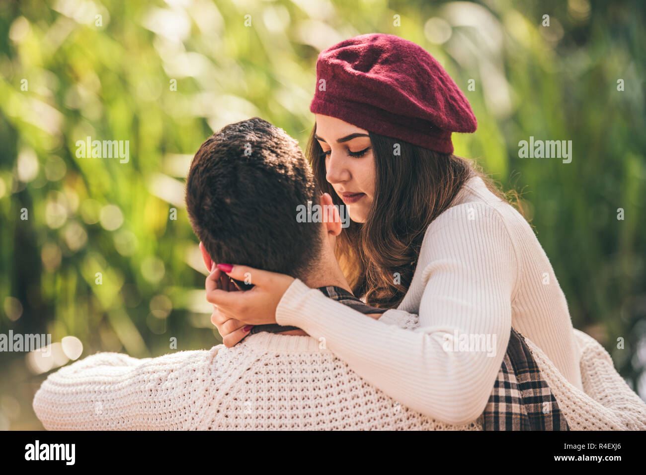 Good looking couple is smiling and having fun in the park, while ...