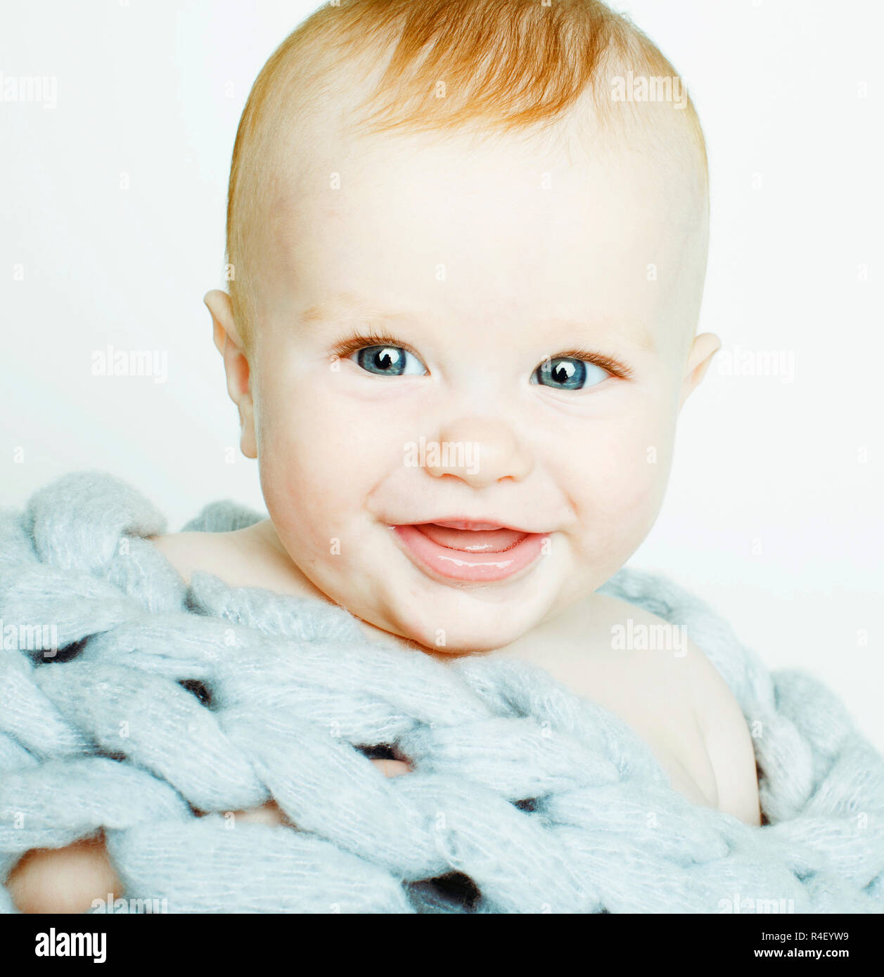 little cute red head baby in scarf all over him close up isolate Stock ...