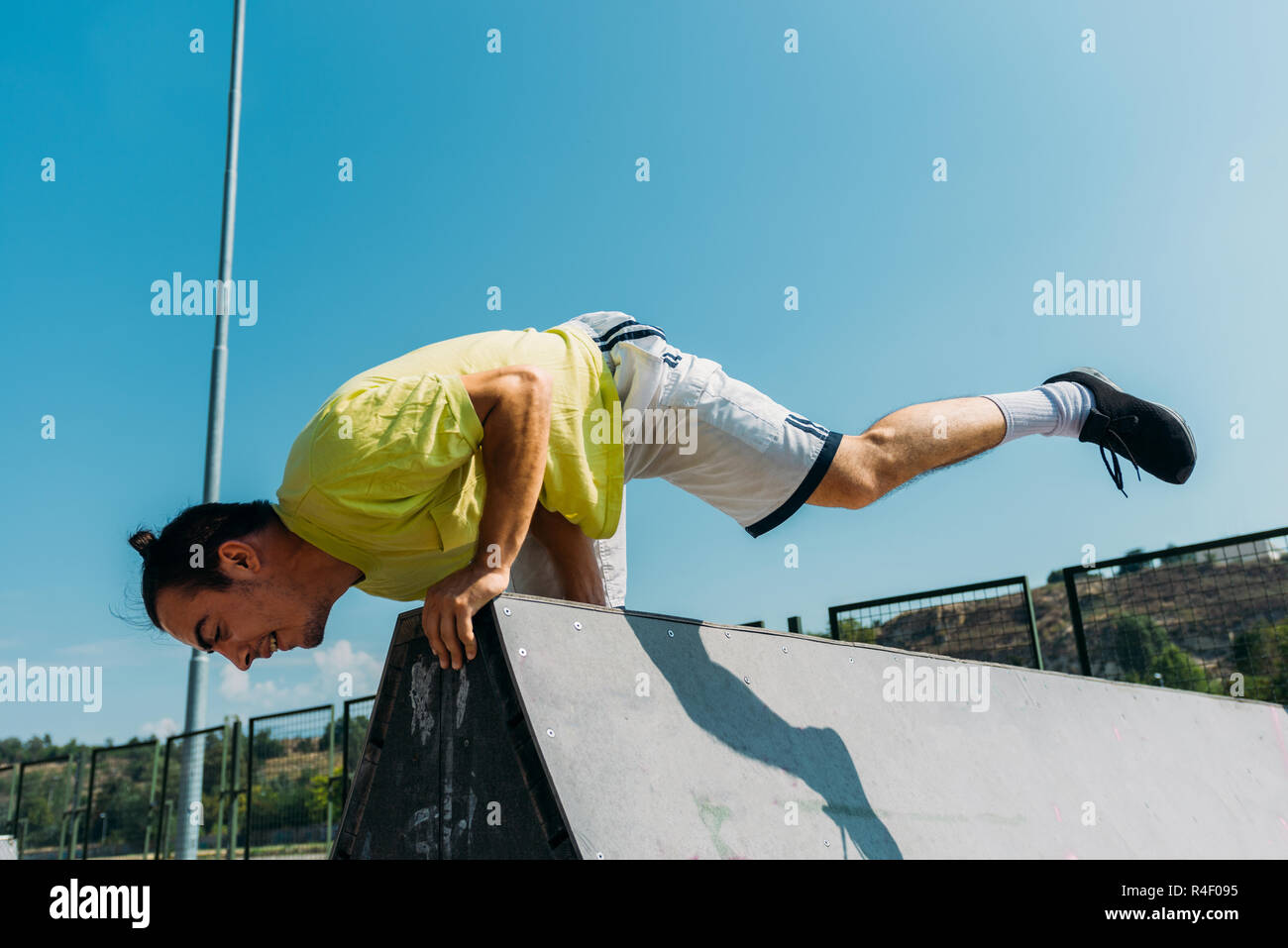 Sporty man maintains a balance on one hand in skatepark Stock Photo - Alamy