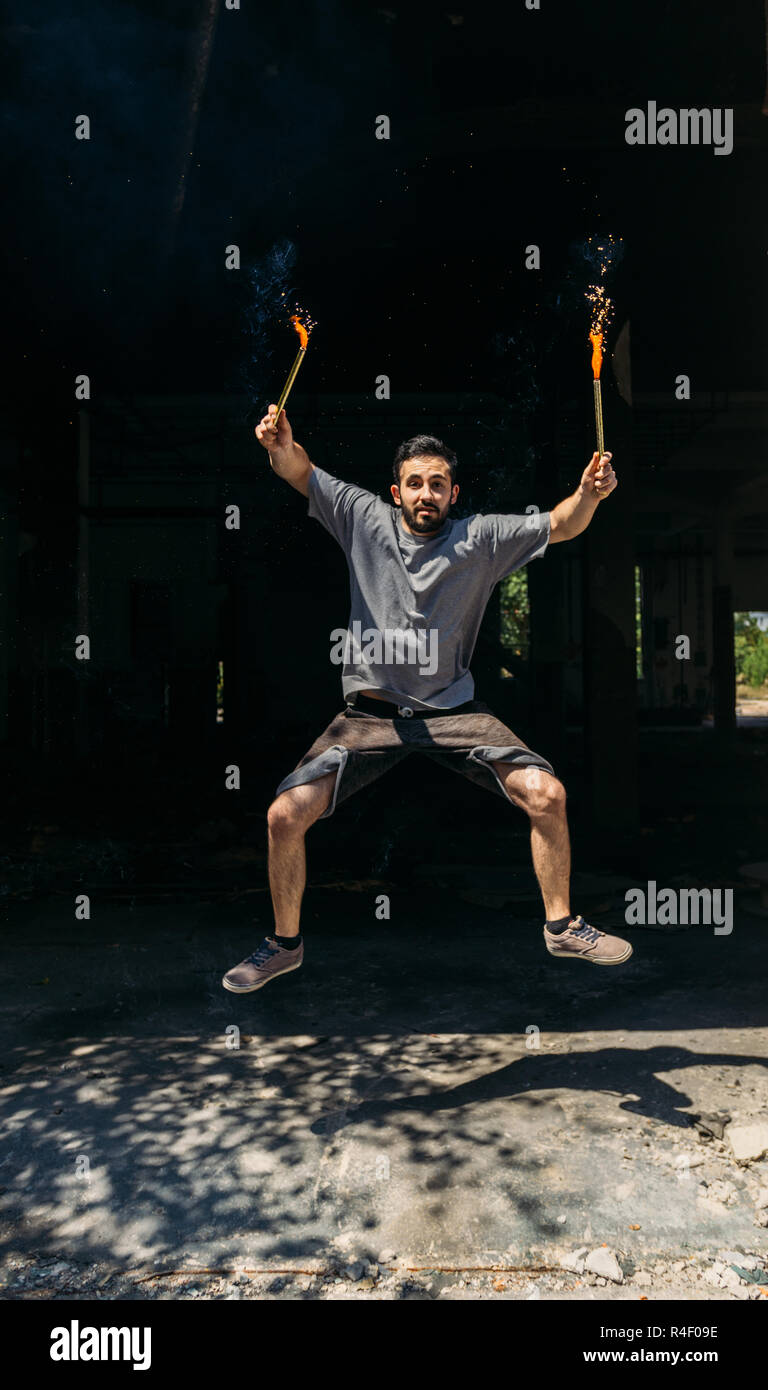 Sporty guy training while jumping with firework candle Stock Photo - Alamy