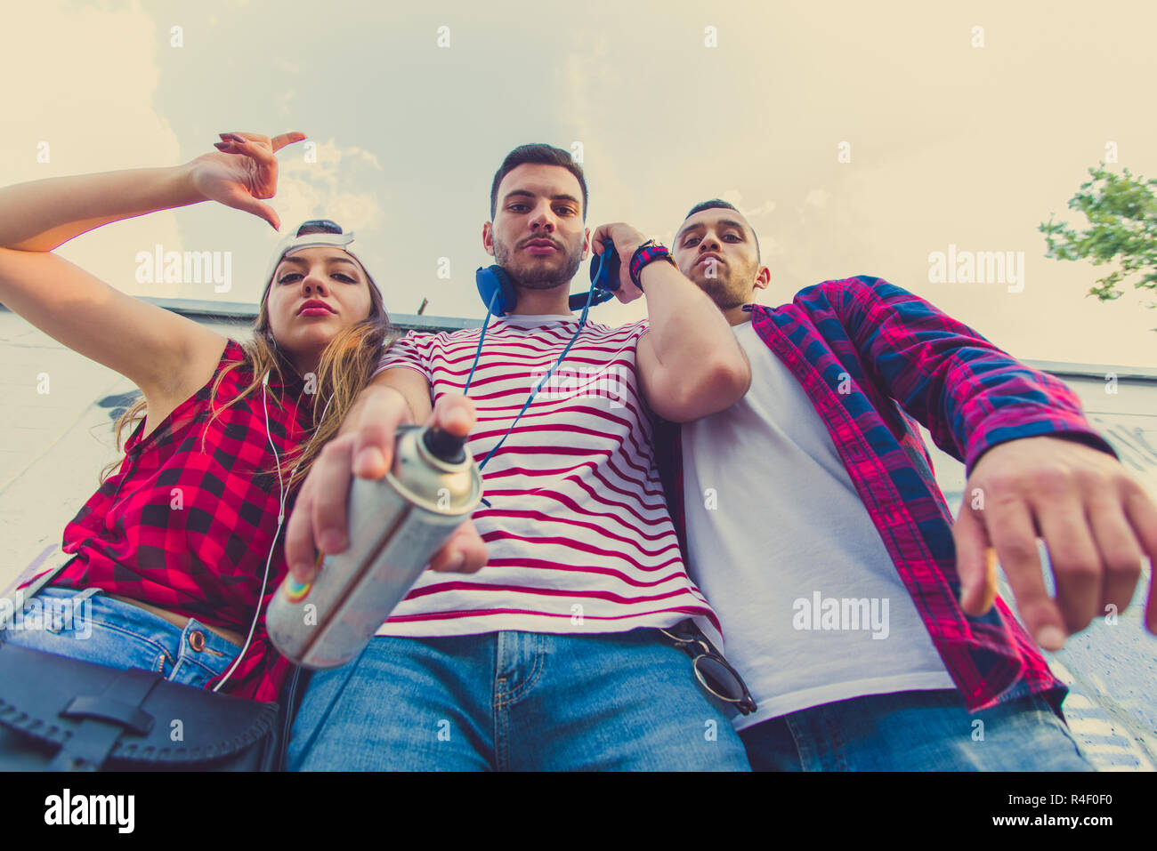 A group of three serious people standing next to each other with spray ...