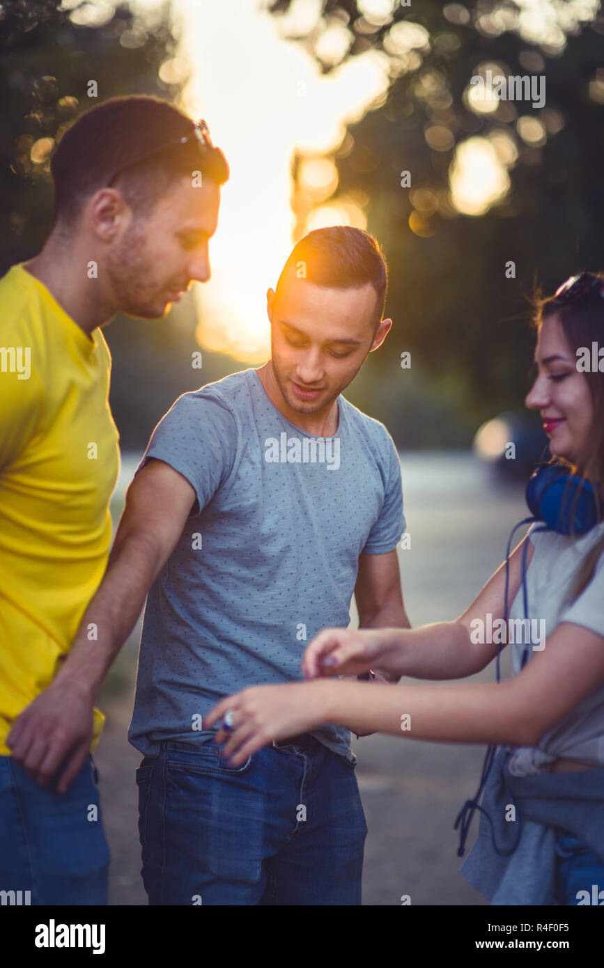 Three friends are hanging out in the park, smiling and having fun Stock ...