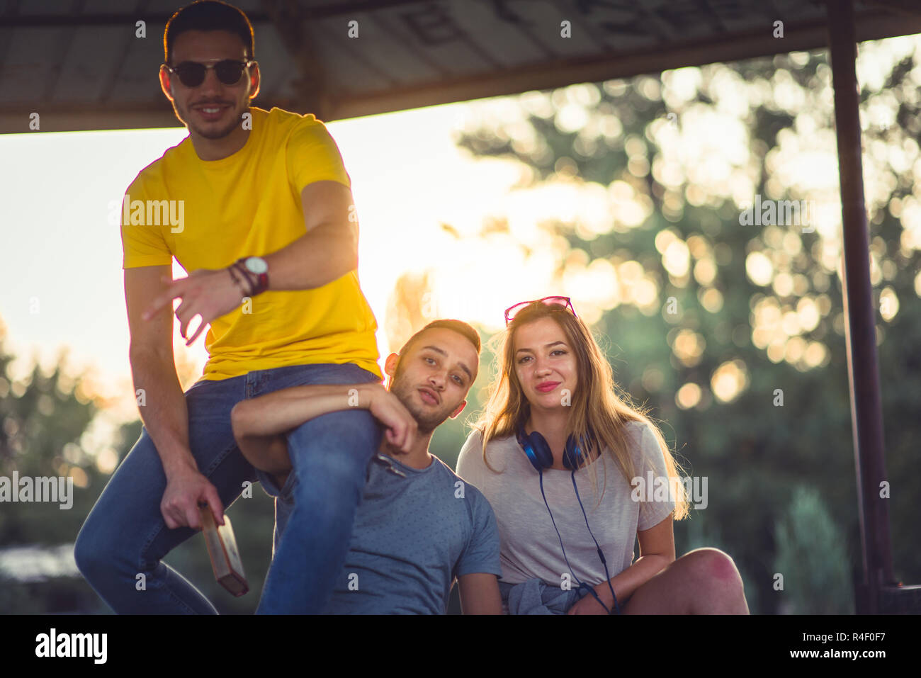 Friends are having fun fooling around and hugging their legs in the ...