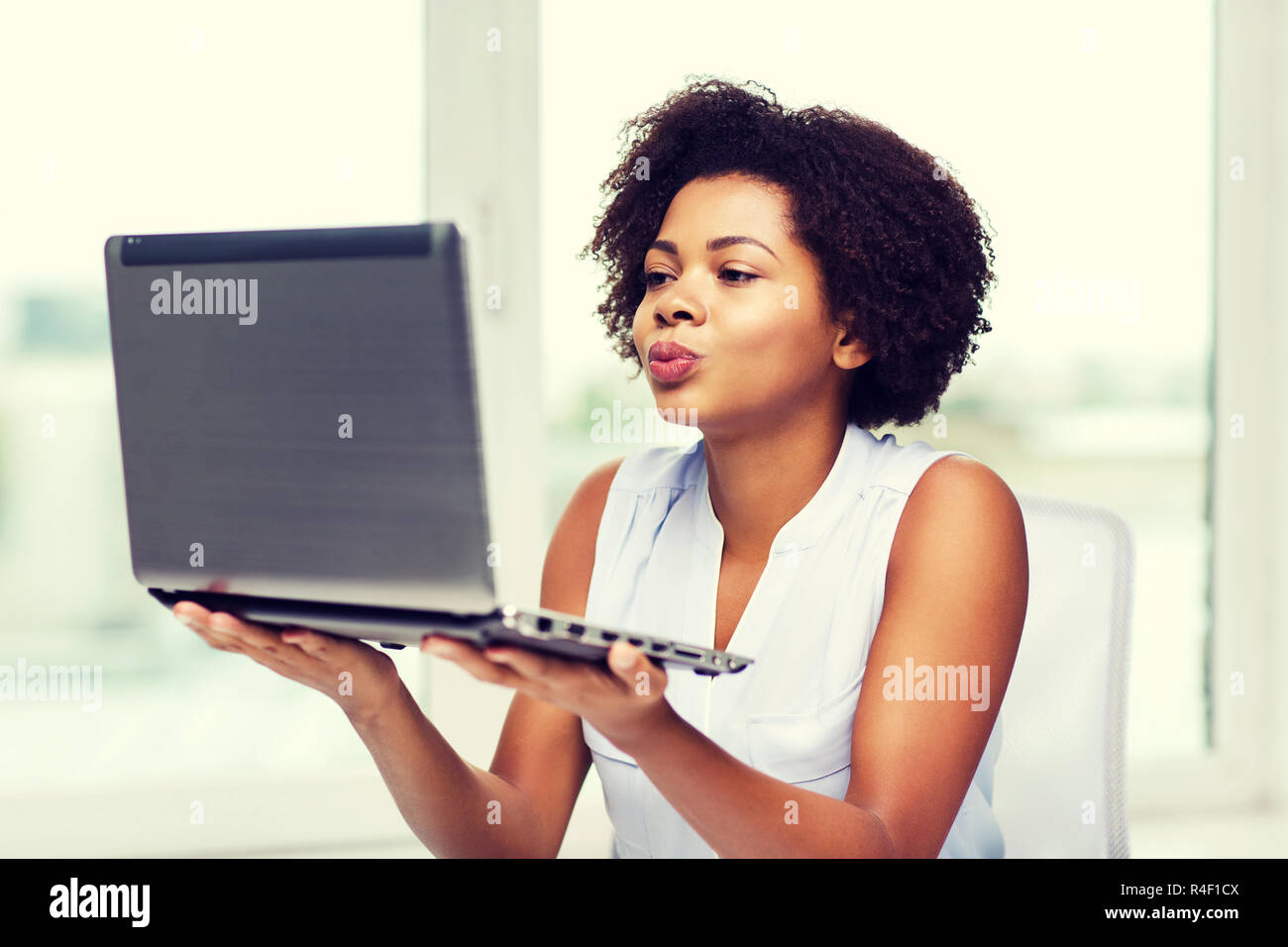 african woman sending kiss to laptop computer Stock Photo - Alamy