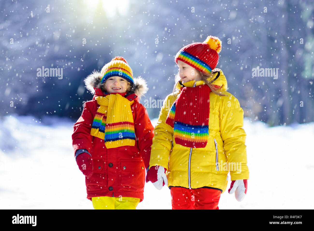 Kids playing in snow. Children play outdoors on snowy winter day. Boy ...