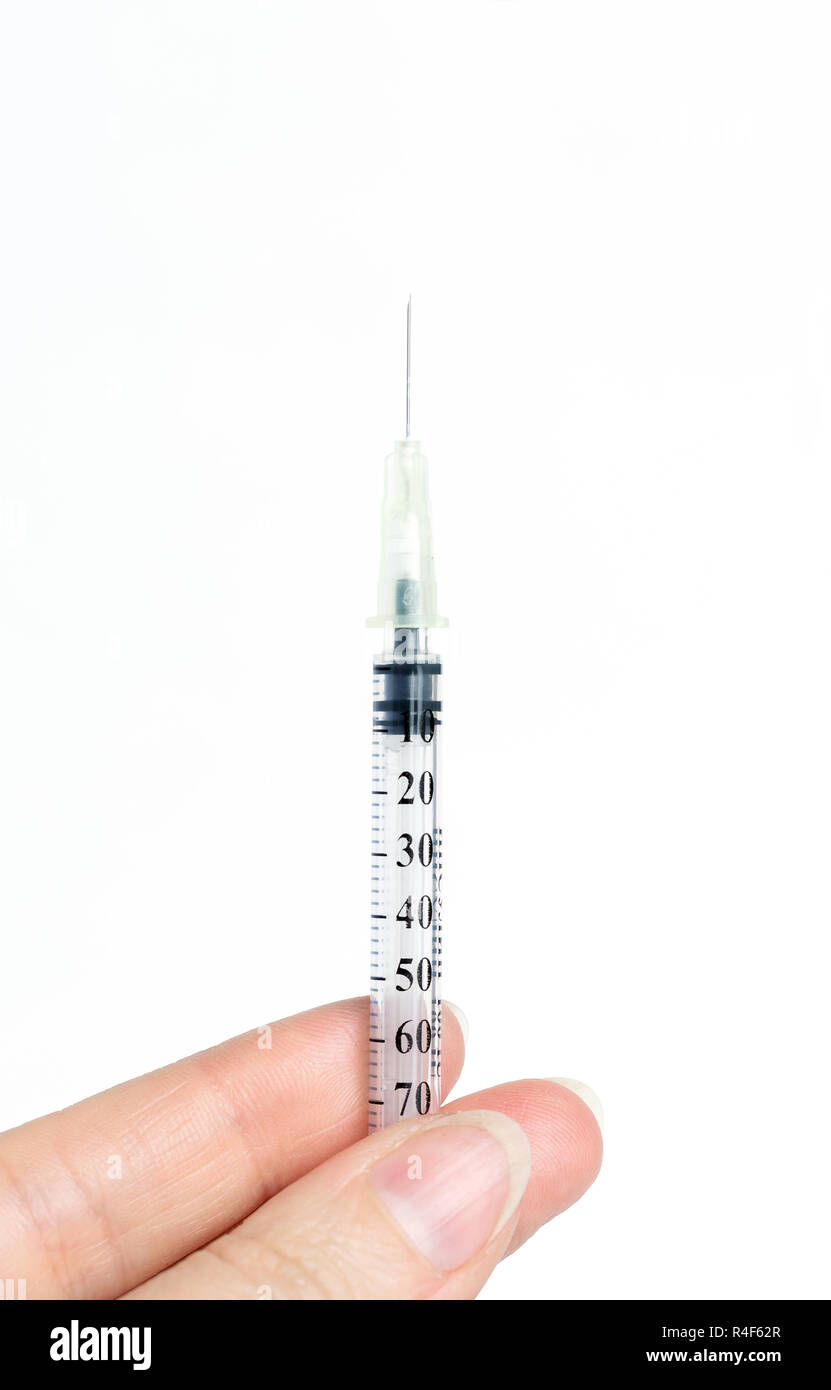 Female hands prepare an insulin syringe for work on a white background ...