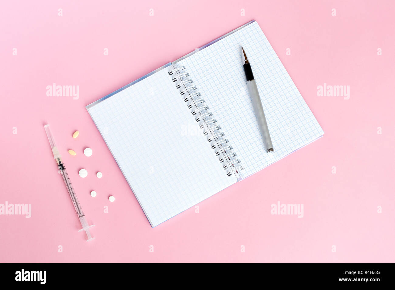 Clean notebook with pen, drugs, syringe on pink background Stock Photo ...