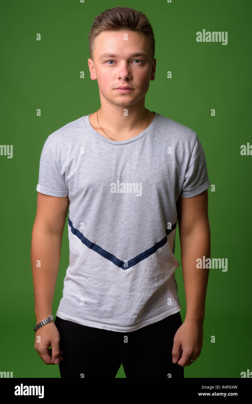 Studio shot of young handsome man against green background Stock Photo ...