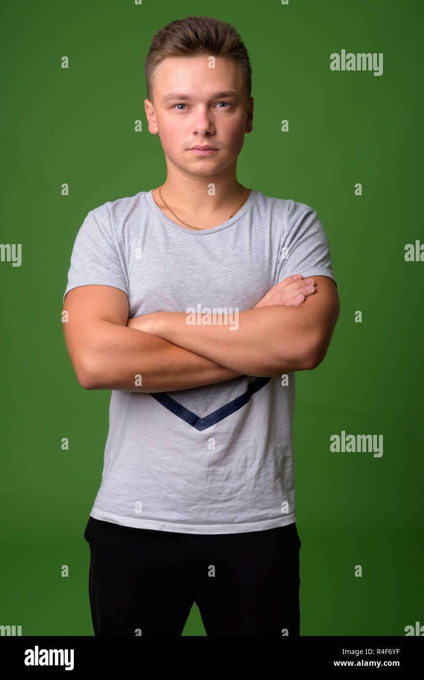 Studio shot of young handsome man against green background Stock Photo ...