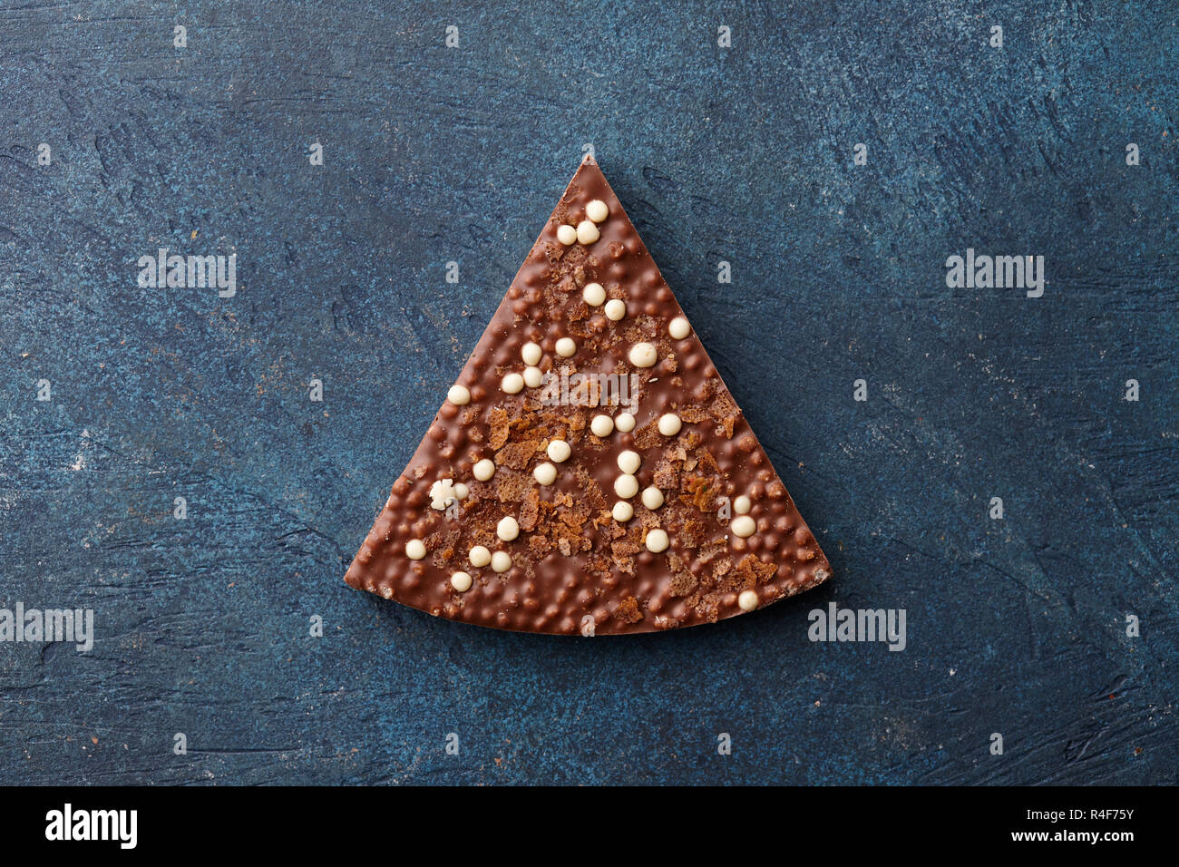 Triangle shaped piece of milk handmade chocolate with rice balls and ...