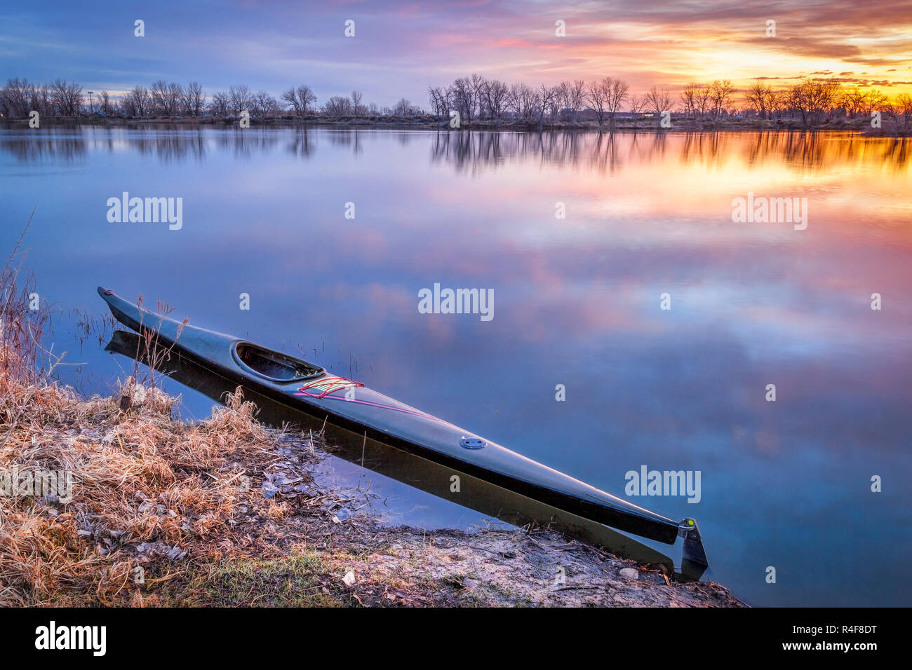 a slim sea racing kayak ready for paddling workout before sunrise on a ...