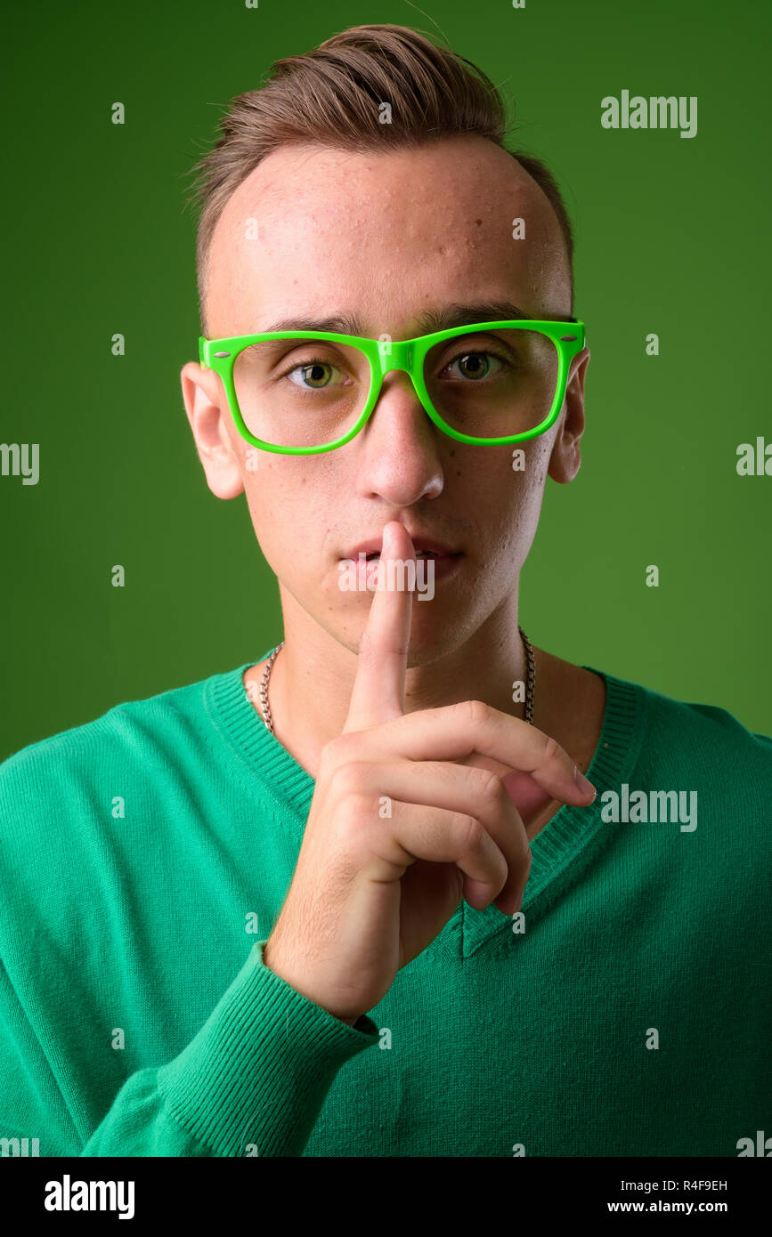 Studio shot of young handsome man against green background Stock Photo ...