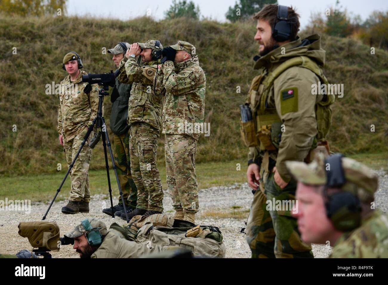 Soldiers from various nations observe Norwegian soldiers as they fire ...