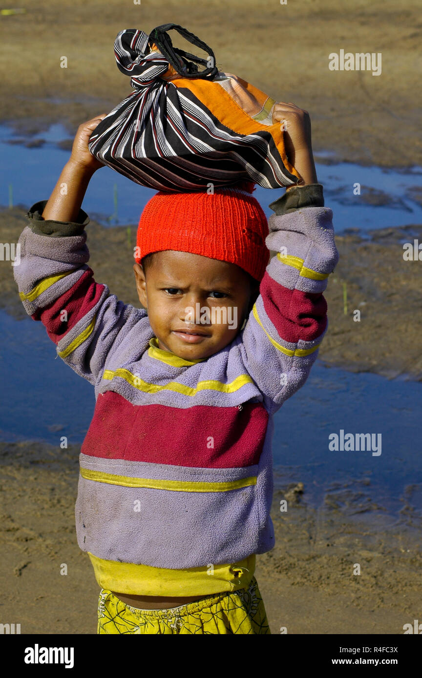 A boy carries meal for his father who is working in the paddy field at ...