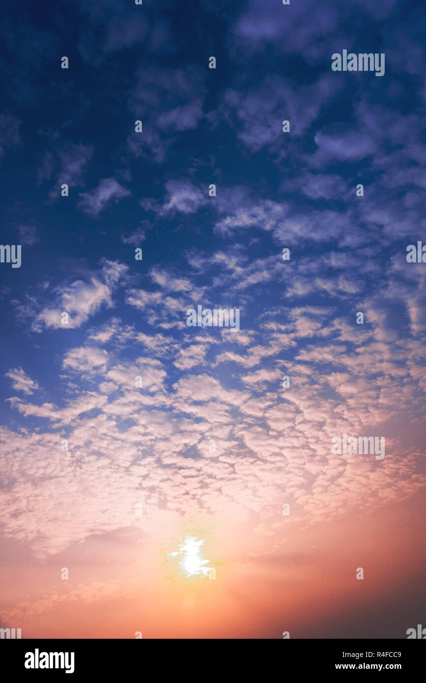 Cumulus sunset clouds with sun setting down Stock Photo - Alamy