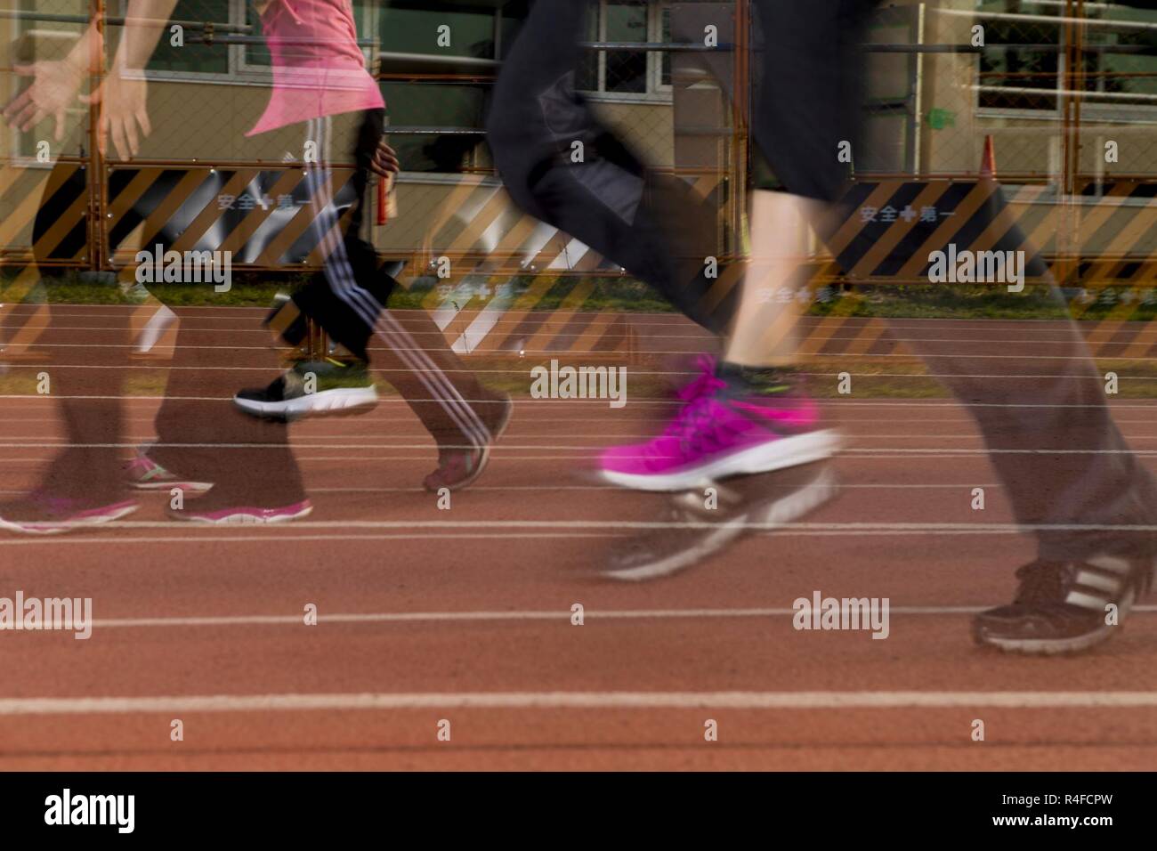 Participants of the Warrior Run fitness program run and walk on track ...