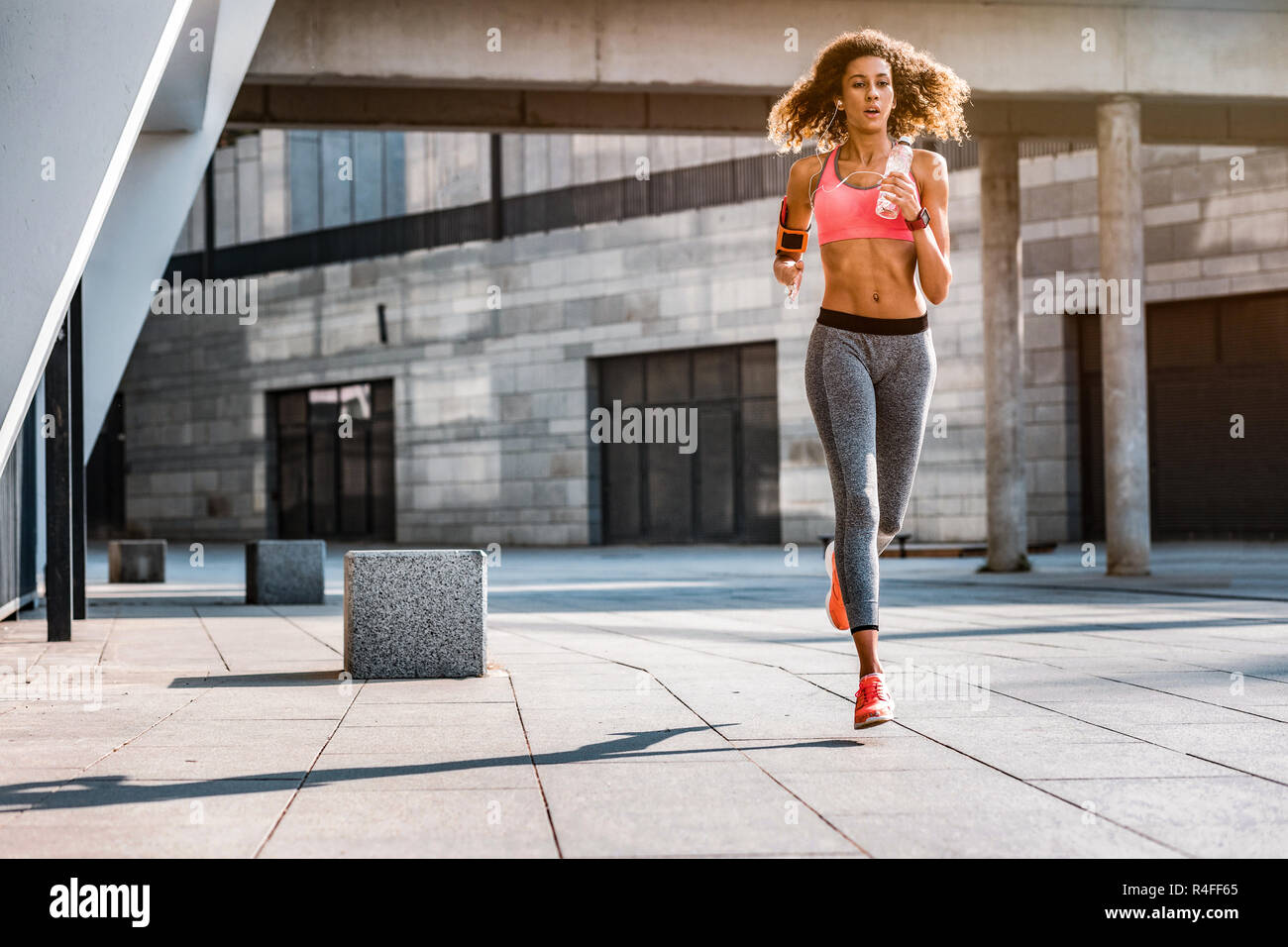 Nice fit woman running with a bottle of water Stock Photo - Alamy