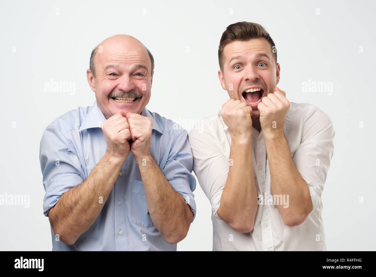 Portrait of a two surprised men father and son or best friends looking ...