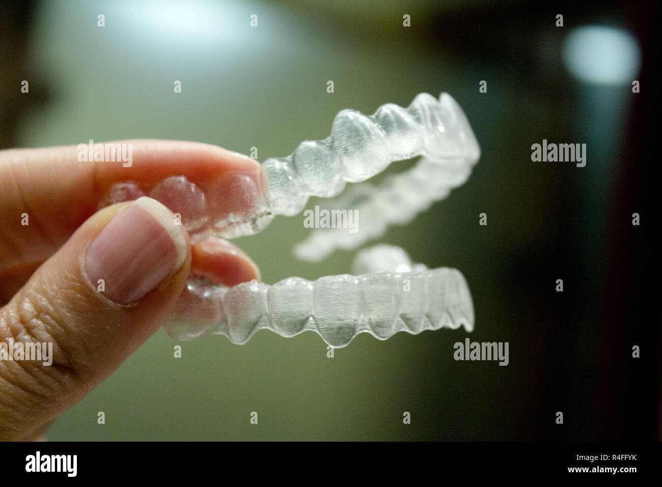 Womans hand holding transparent dental orthodontics to correct the ...