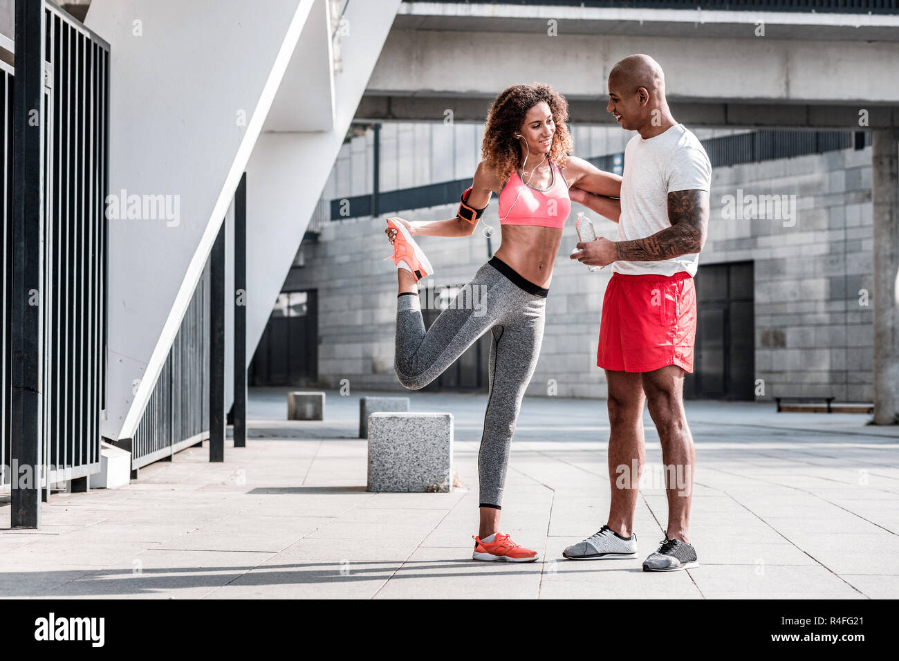 Delighted cheerful young man supporting his friend Stock Photo - Alamy