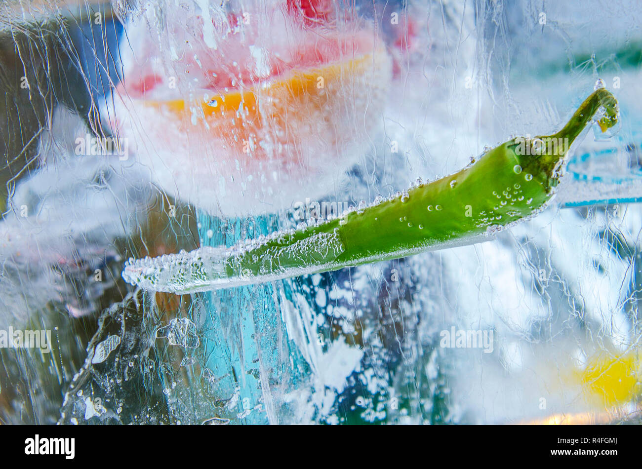 Bitter pepper frozen in ice. Green chili pepper in ice Stock Photo - Alamy