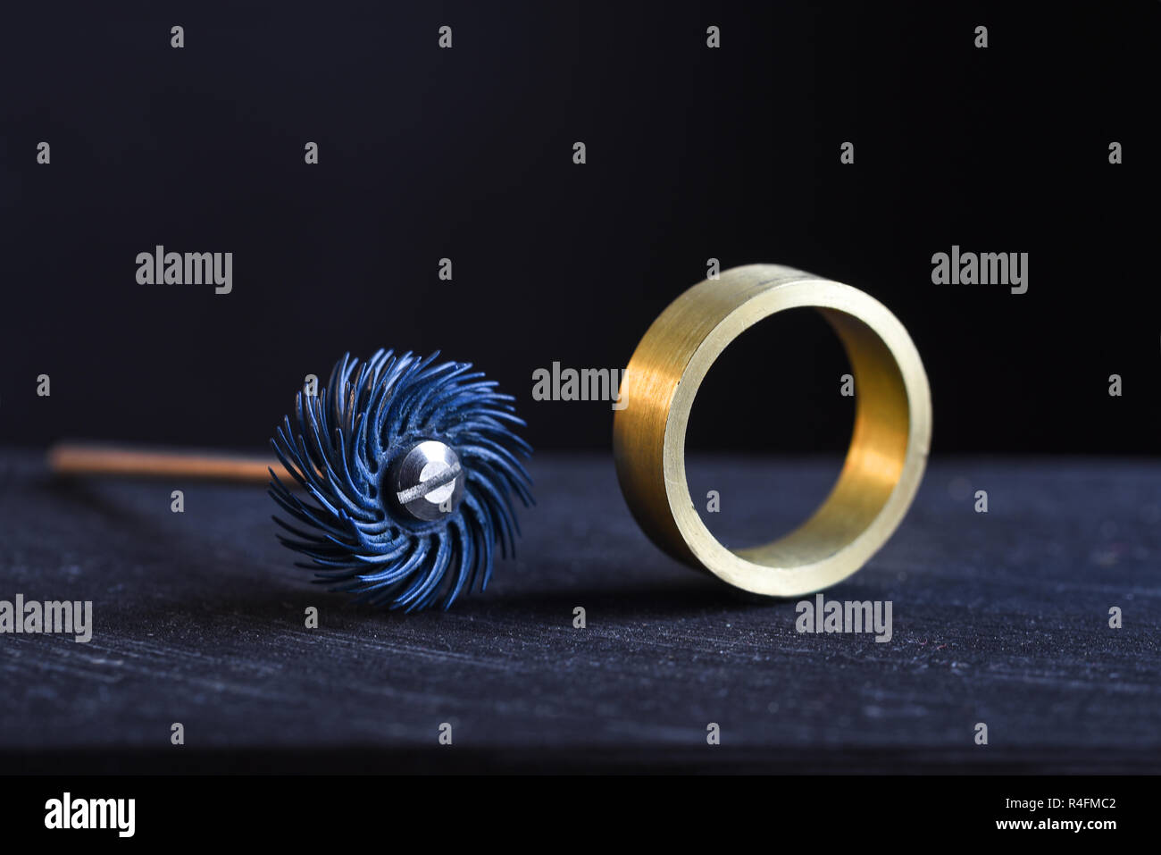 ring from gold and a polishing tool on the workbench of a goldsmith ...