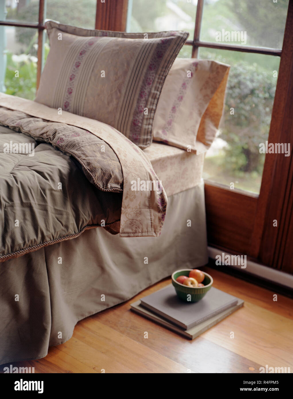 Bed in a room beside a window Stock Photo - Alamy