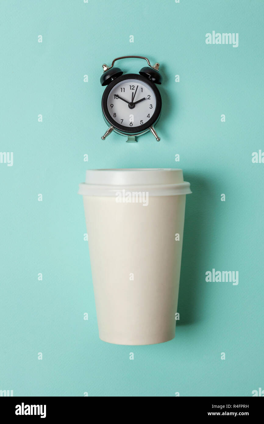 Simply flat lay design paper coffee cup and alarm clock on blue pastel ...