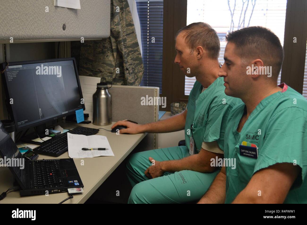 Army Officer Candidate Shane Tracy (left) looks at an X-ray with ...