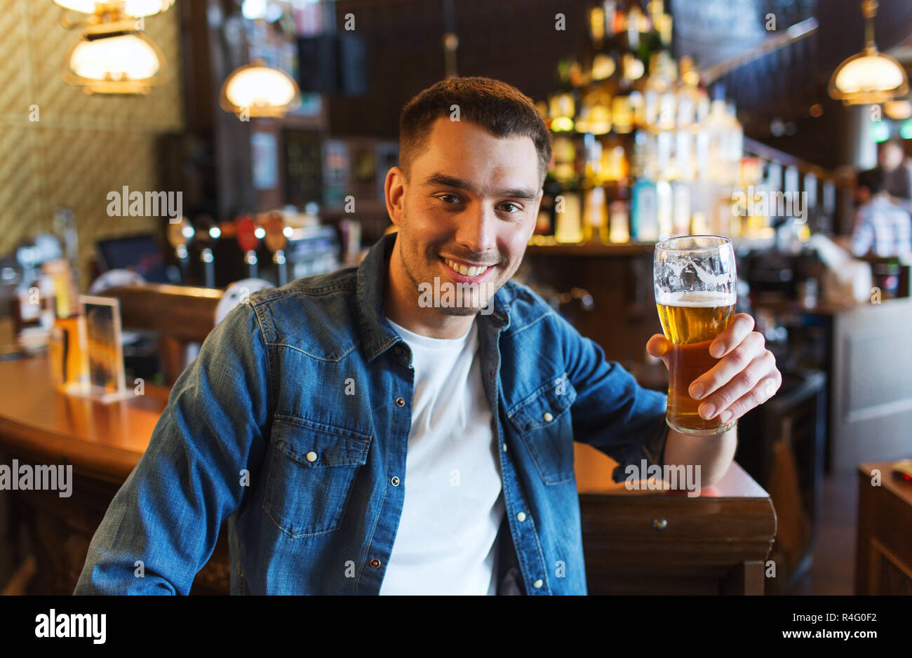 happy man drinking beer at bar or pub Stock Photo - Alamy