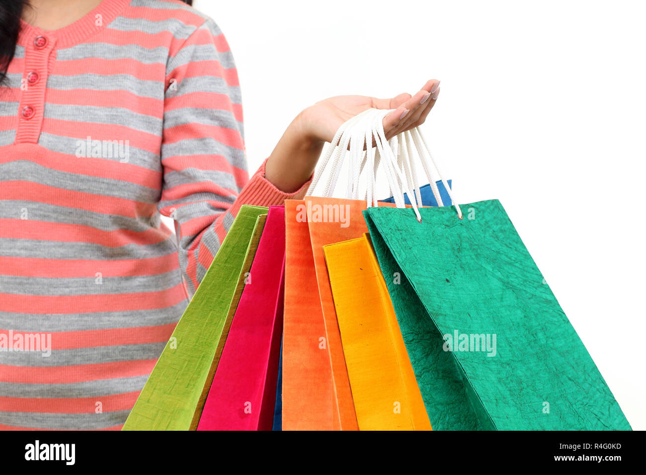 Female hand holding colorful shopping bags against white Stock Photo ...