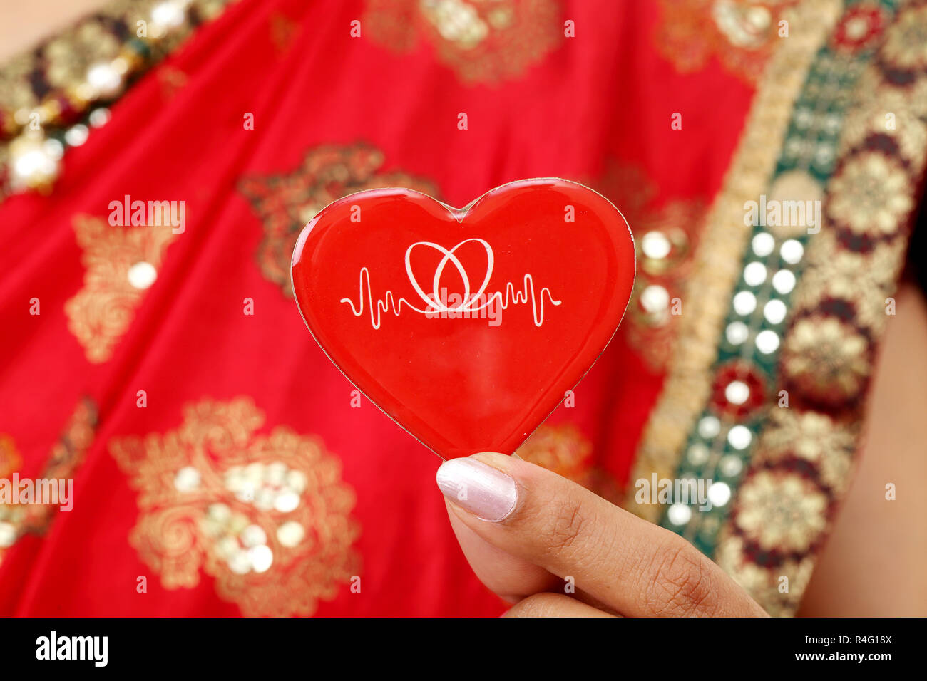 Traditional indian woman holding red heart shape Stock Photo - Alamy