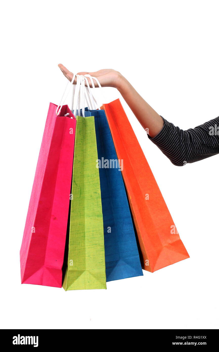 Female hand holding colorful shopping bags against white Stock Photo ...