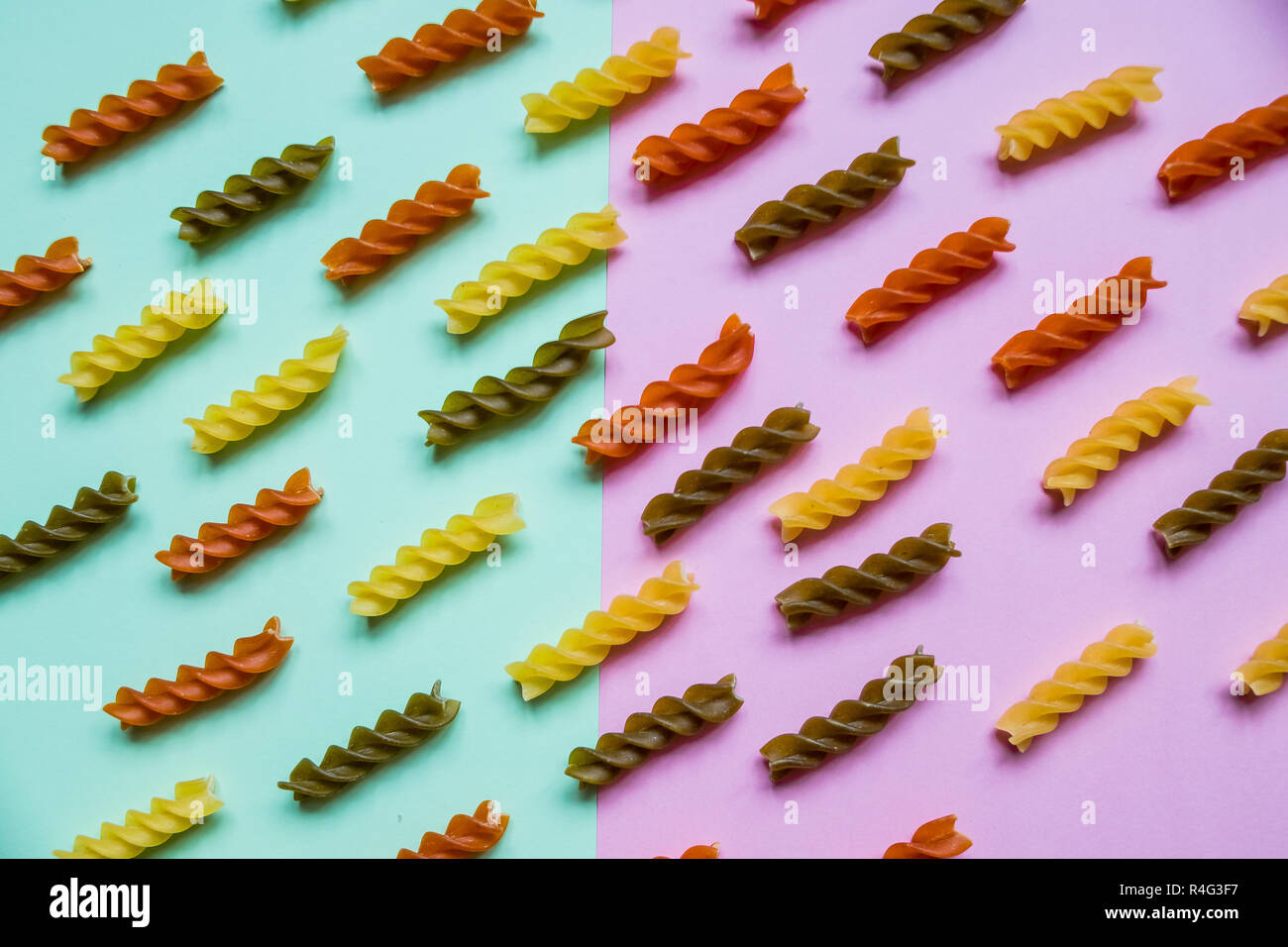 Italian pasta pattern on pink green background. Various colors of pasta ...