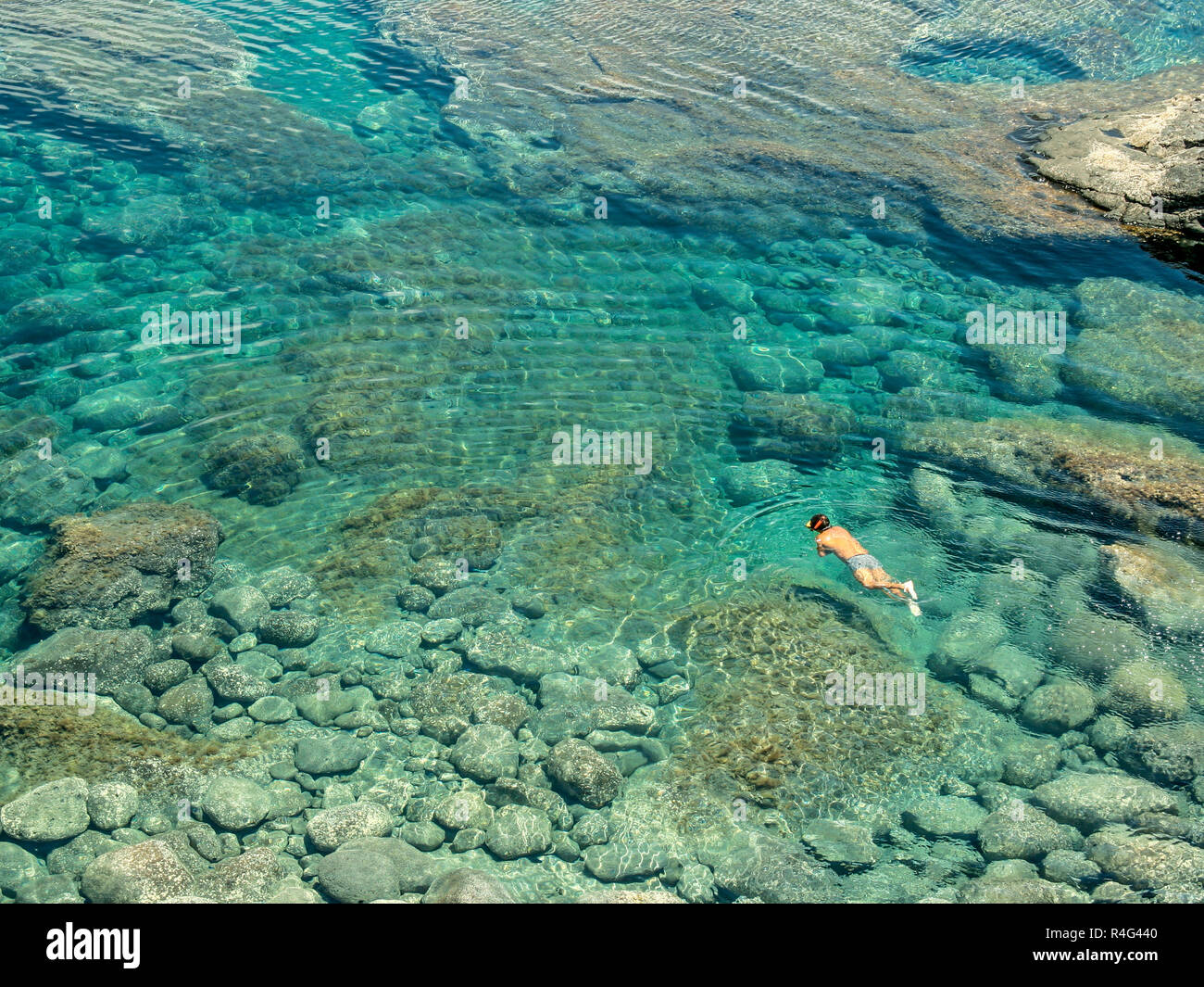 people diving in a natural basin in the ocean Stock Photo - Alamy