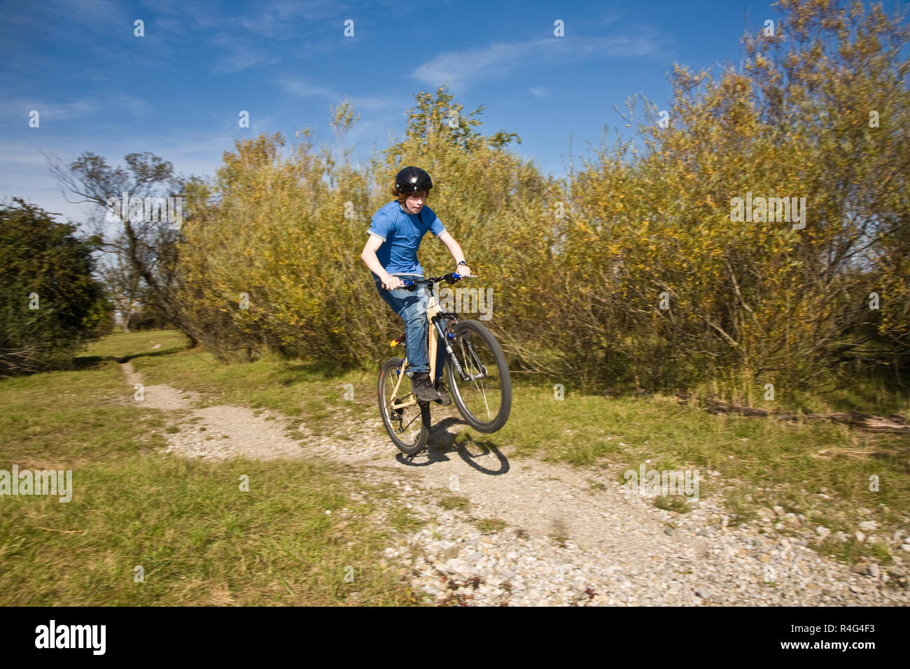 young boy is riding with the dirtbike and racing in the landscape ...