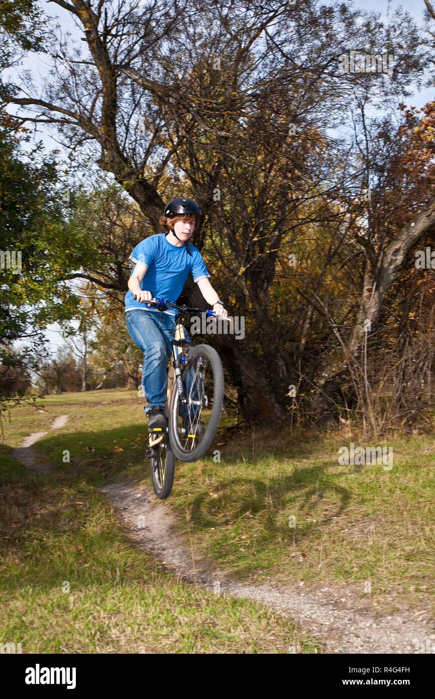 young boy is riding with the dirtbike and racing in the landscape ...