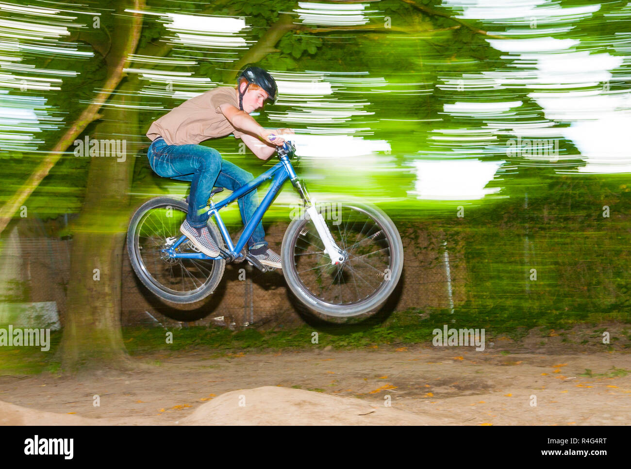 child has fun jumping with the bike over a ramp Stock Photo - Alamy
