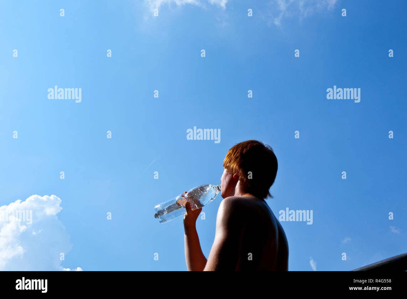 young boy drinks water out of a bottle Stock Photo - Alamy