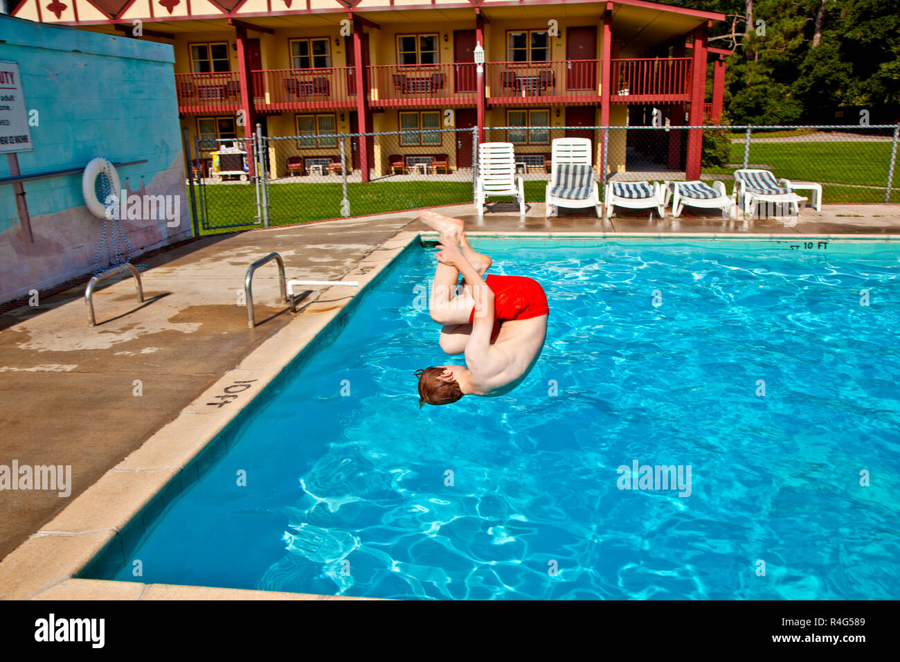 Happy Teenagers Jumping Into Outdoor Pool High Resolution Stock ...
