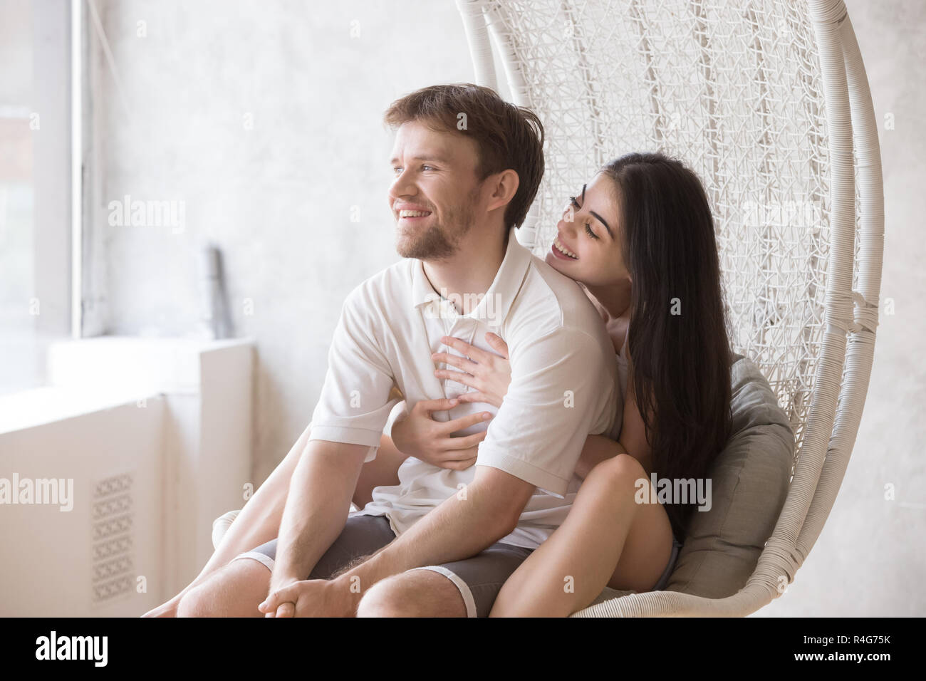 Happy loving couple sitting together in lounge hanging chair Stock ...