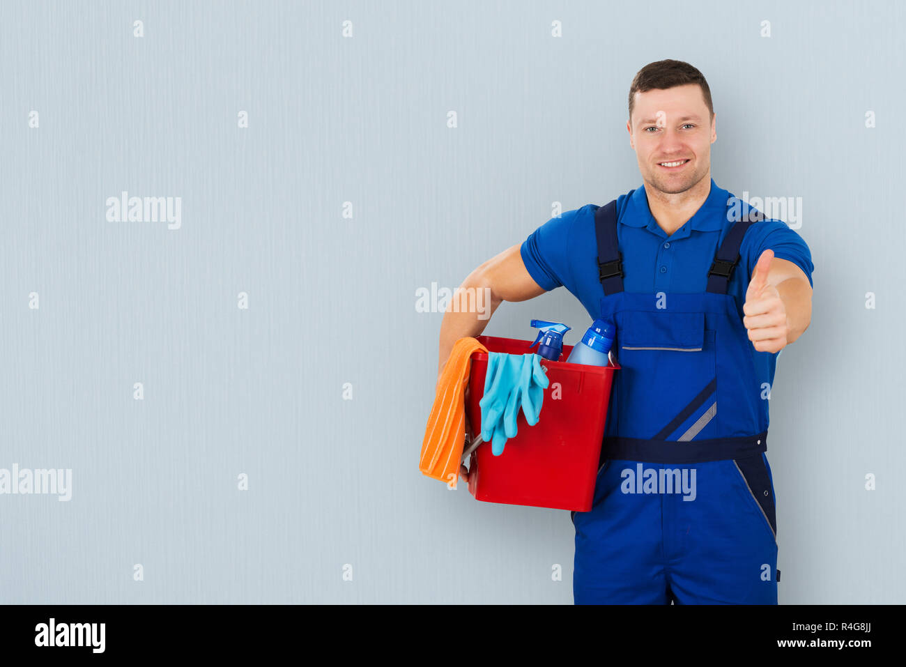 Janitor Showing Thumbs Up While Carrying Bucket Stock Photo - Alamy