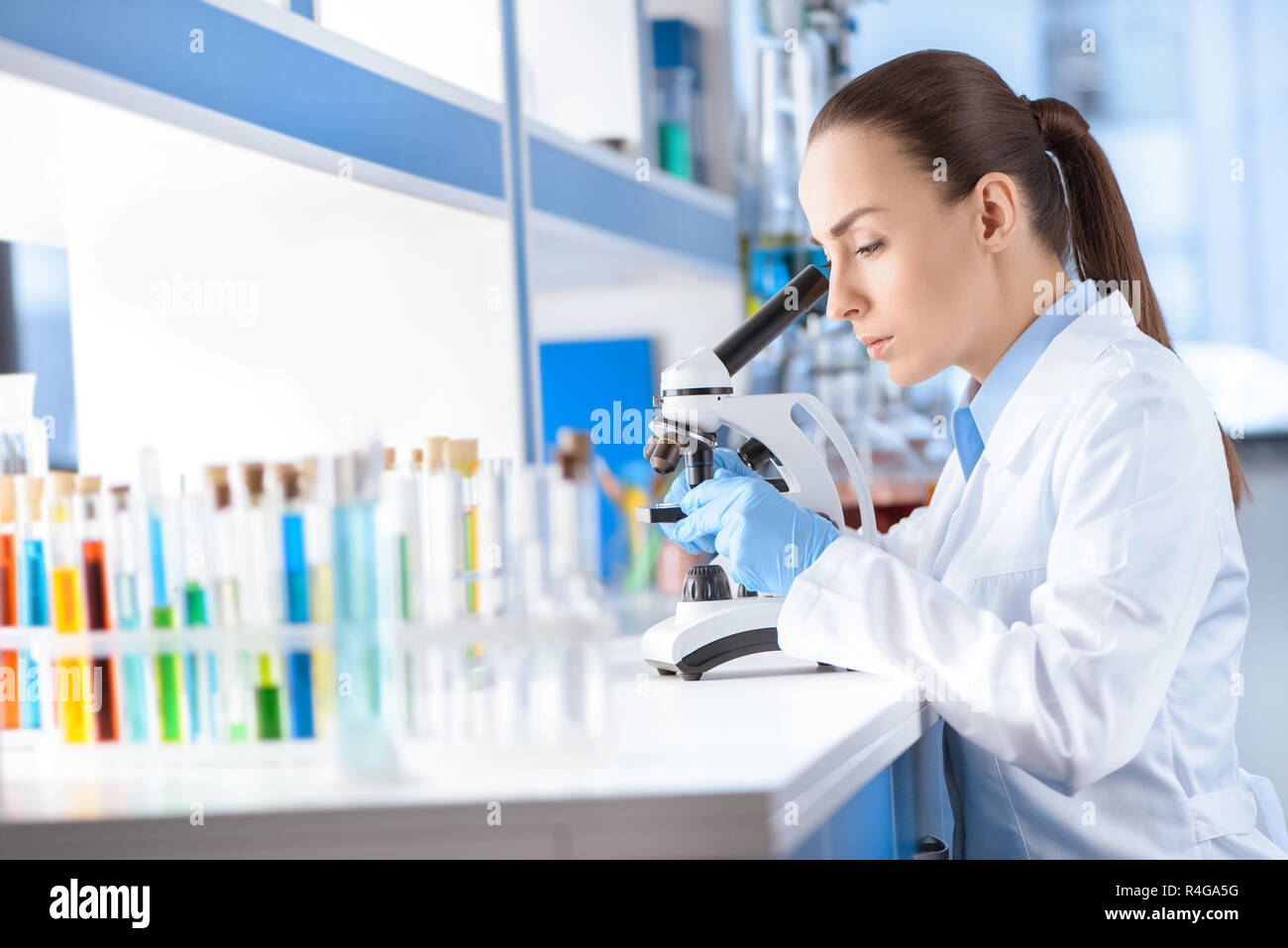 side view of concentrated scientist working with microscope Stock Photo ...