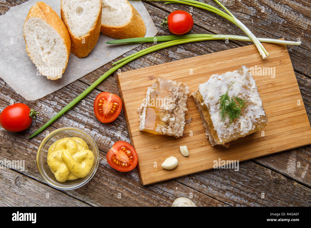 Homemade jelly meat with mustard, bread, tomatoes and garlic on the ...