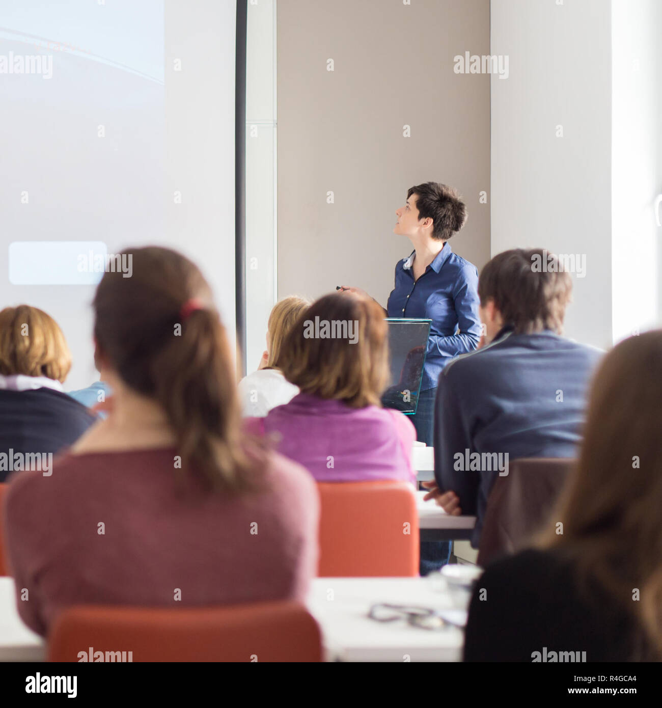 Woman giving presentation in lecture hall at university Stock Photo - Alamy